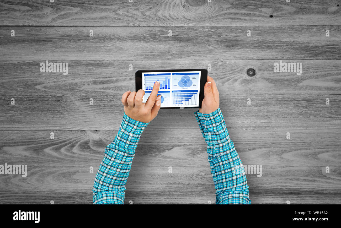 Top view of girl hands using tablet pc with diagrams and graphs on ...
