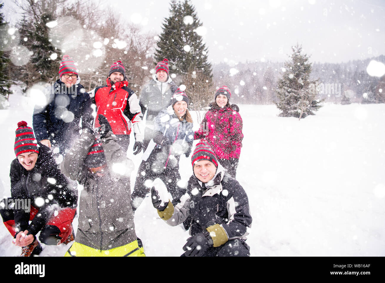 group of young happy business people having fun throwing snow in the ...
