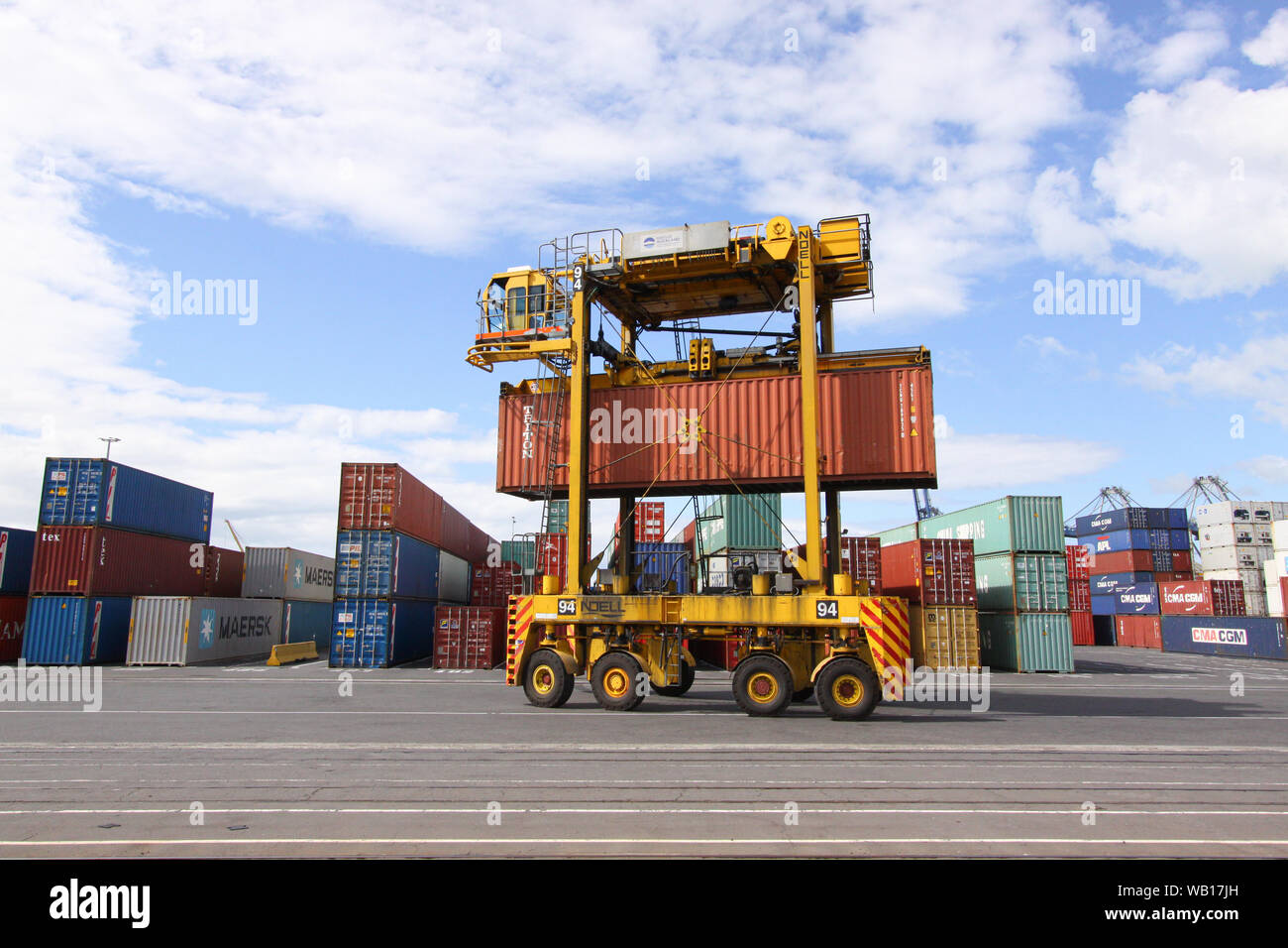 Driving Straddle Carrier (Van Carrier) with a container in the harbour ...