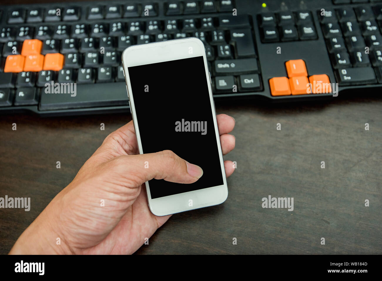 hand using mobile phone at computer Stock Photo - Alamy