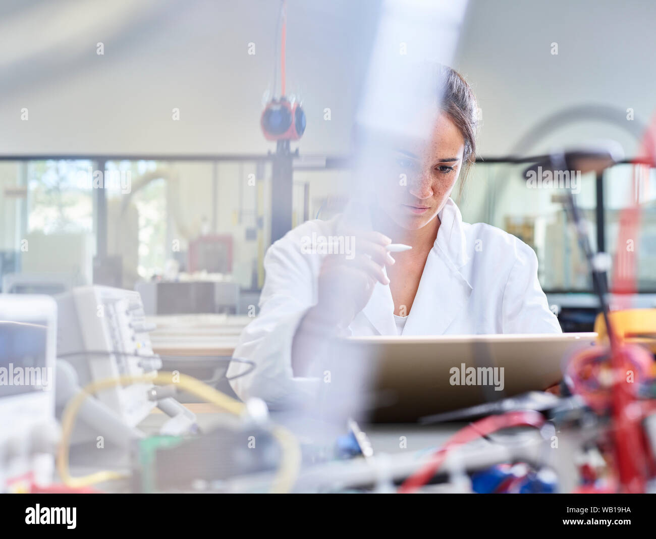Female technician working in research laboratory, drawing with stylus ...