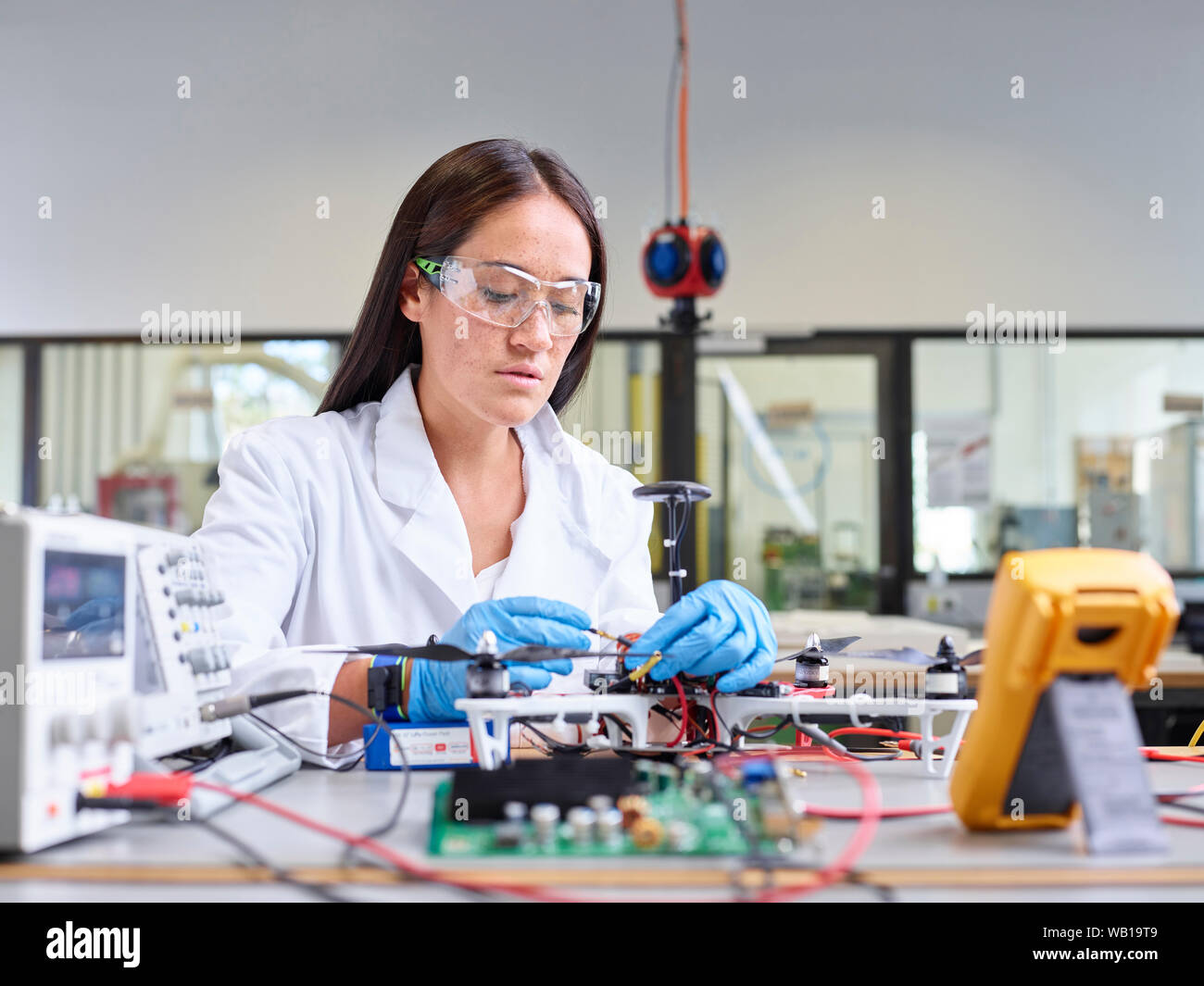 Female technician working in research laboratory, connecting plug of ...