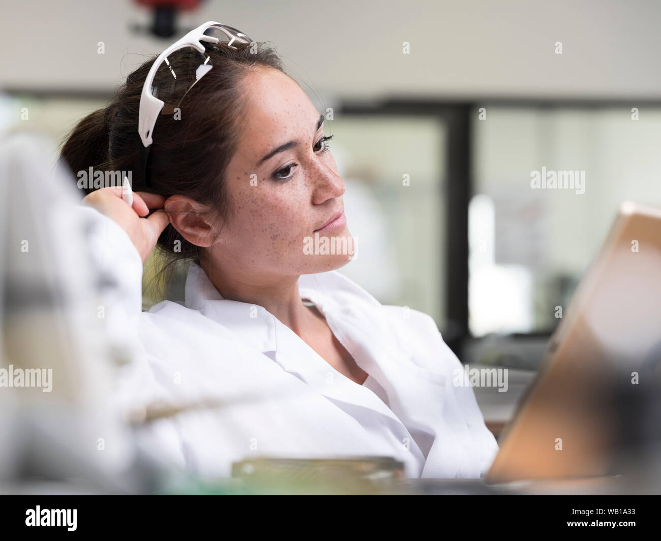 Female technician working in research laboratory in front of tablet ...
