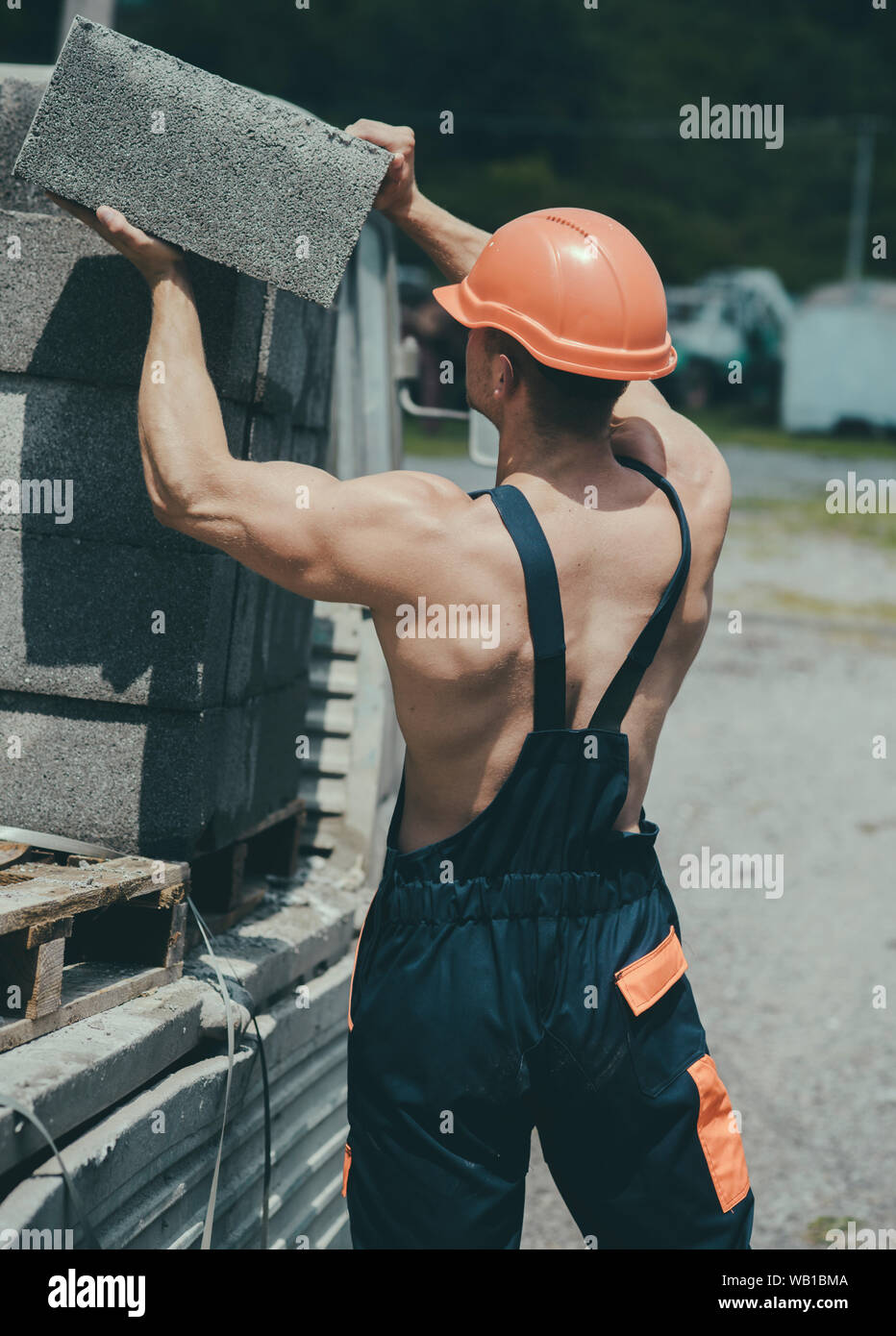Construction concept. Man carry bricks for construction works. Builder ...