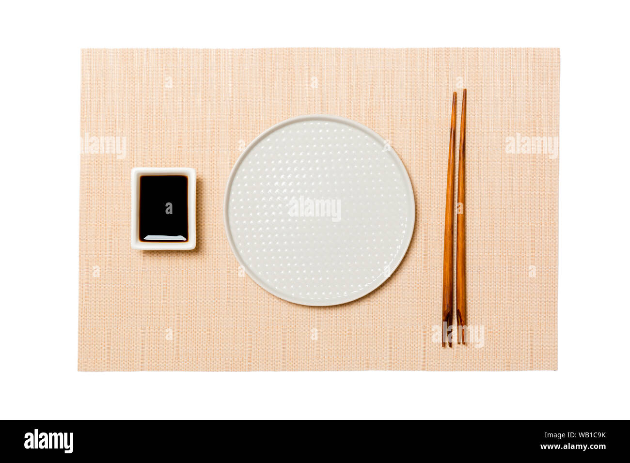 Empty round white plate with chopsticks for sushi and soy sauce on ...