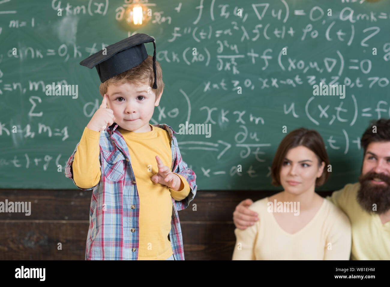 Wunderkind concept. Smart child, wunderkind in graduate cap pointing at ...