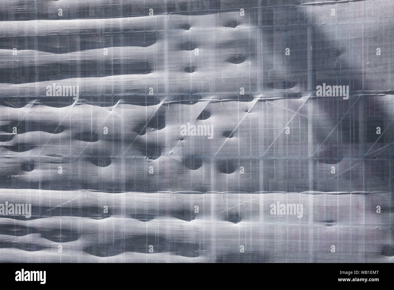 Protective white textile cover sheet on scaffolding on construction ...