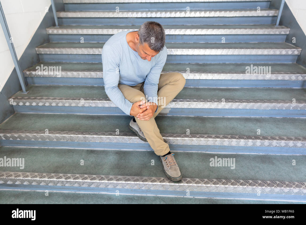 Mature Man Sitting On Staircase After Slip And Fall Accident Stock ...
