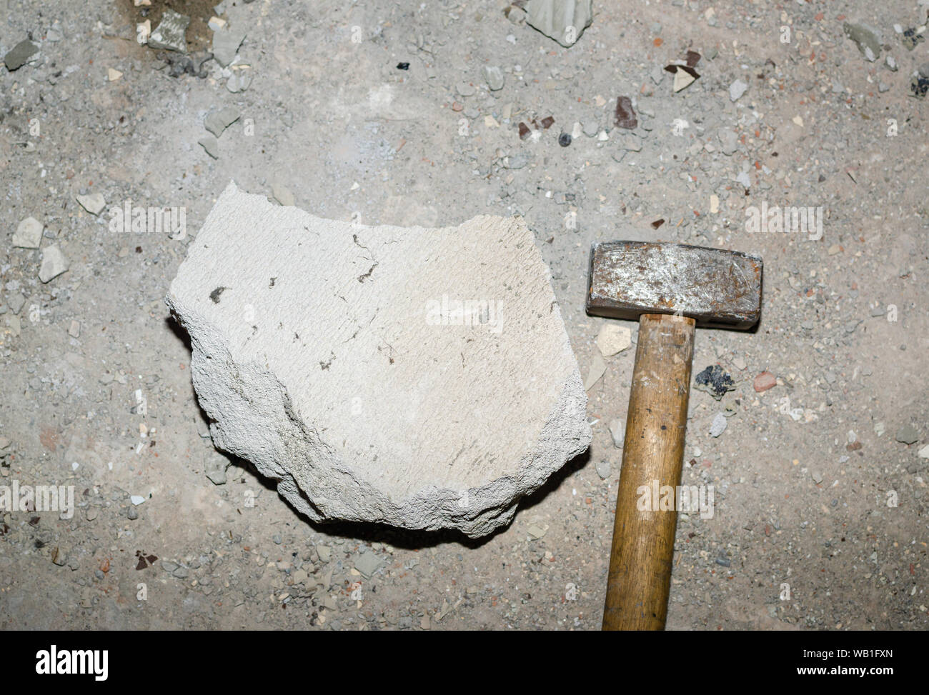 Hammer and a part of a plaster after wall breaking Stock Photo - Alamy