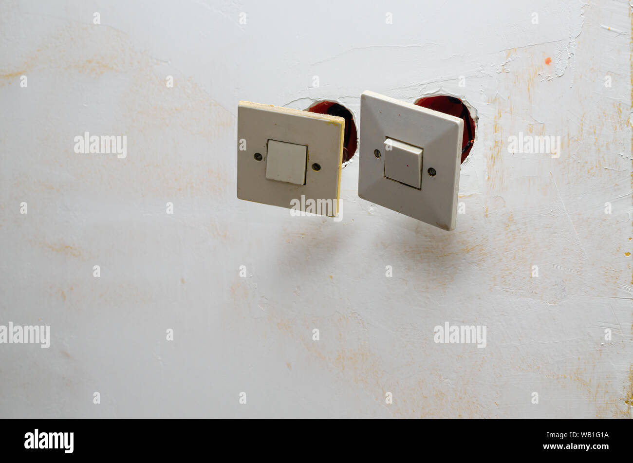 Old switches detached from a wall during renovation works in an ...