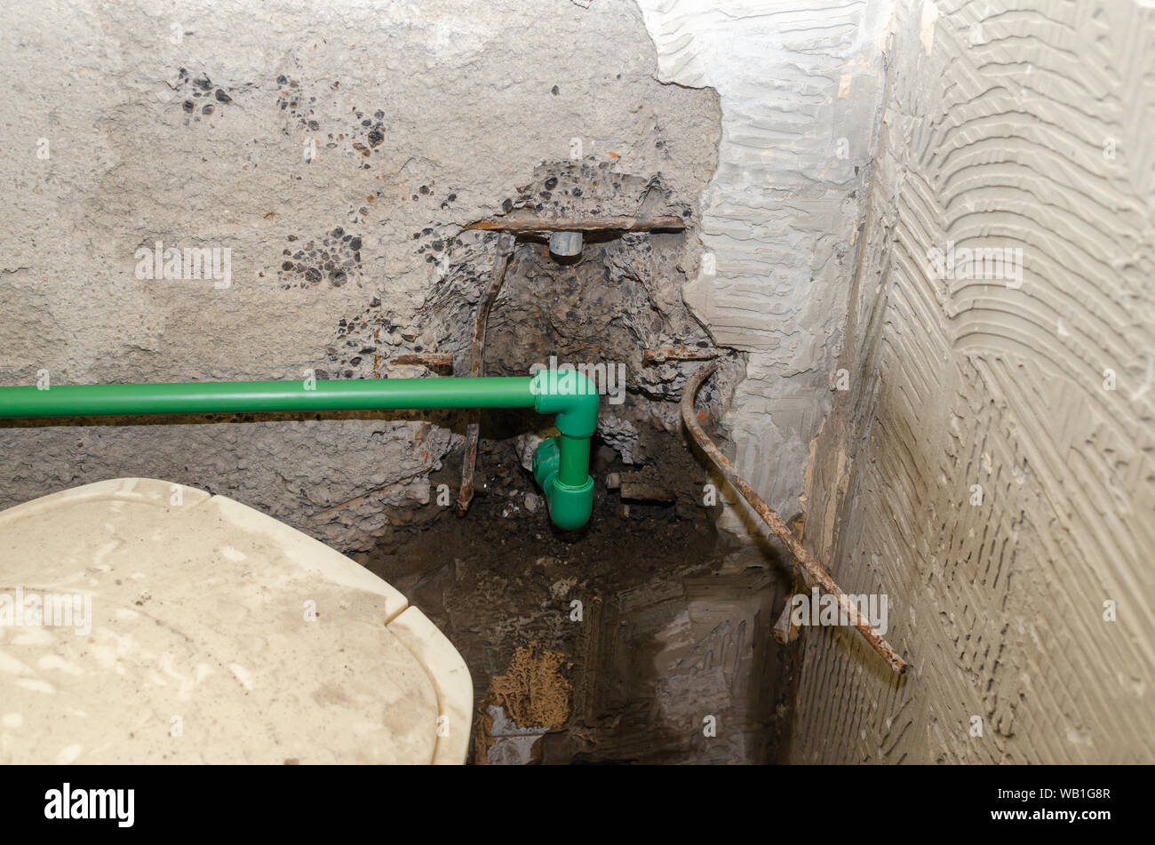 New plastic water pipes installed in scraped bathroom wall during ...