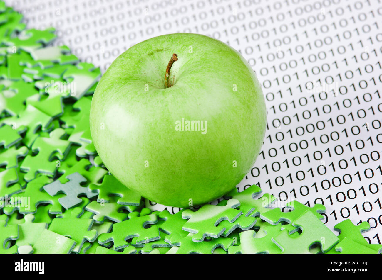 green apple and puzzles on a binary code Stock Photo - Alamy