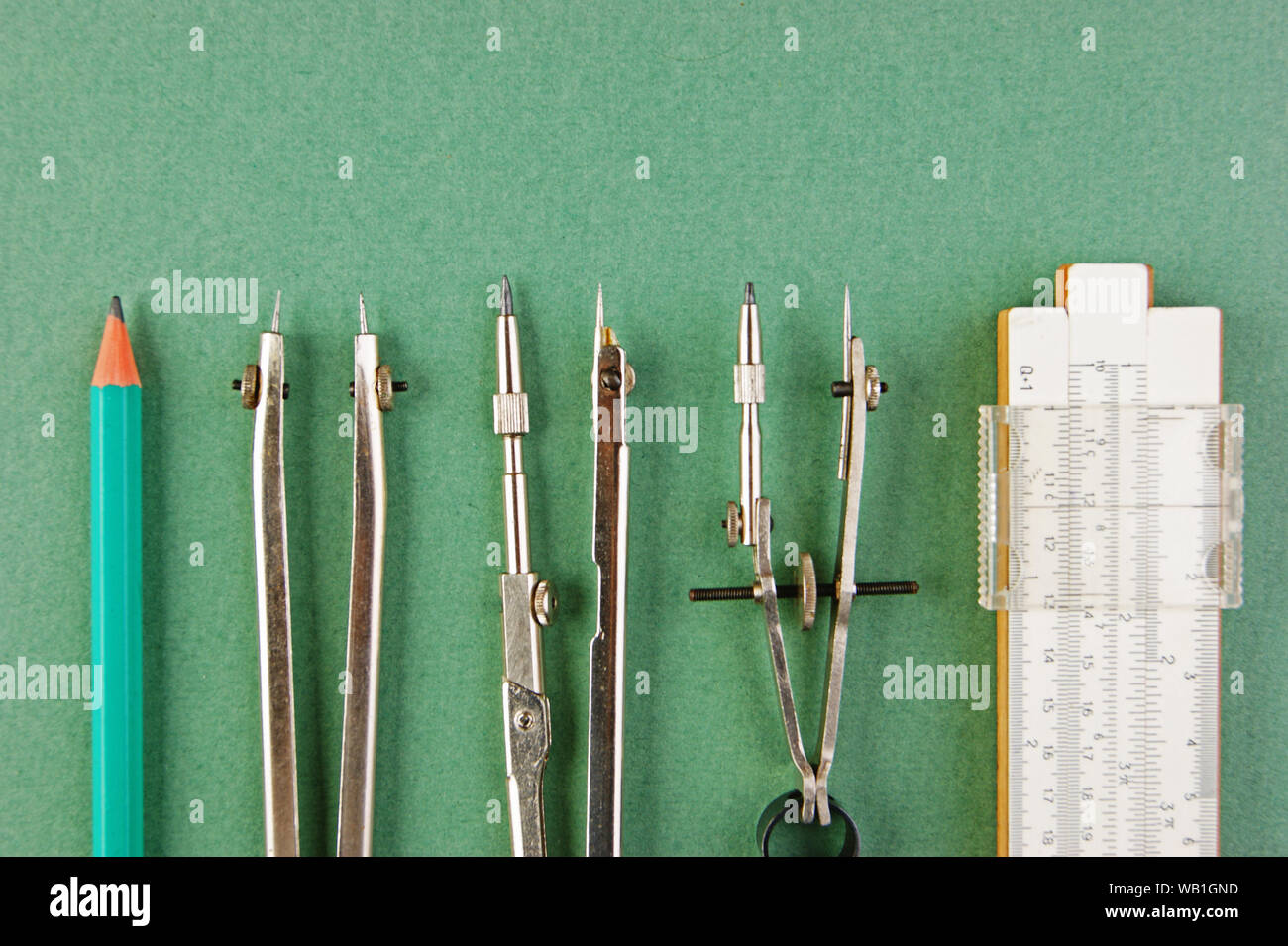 Old drawing tools on a green background Stock Photo - Alamy