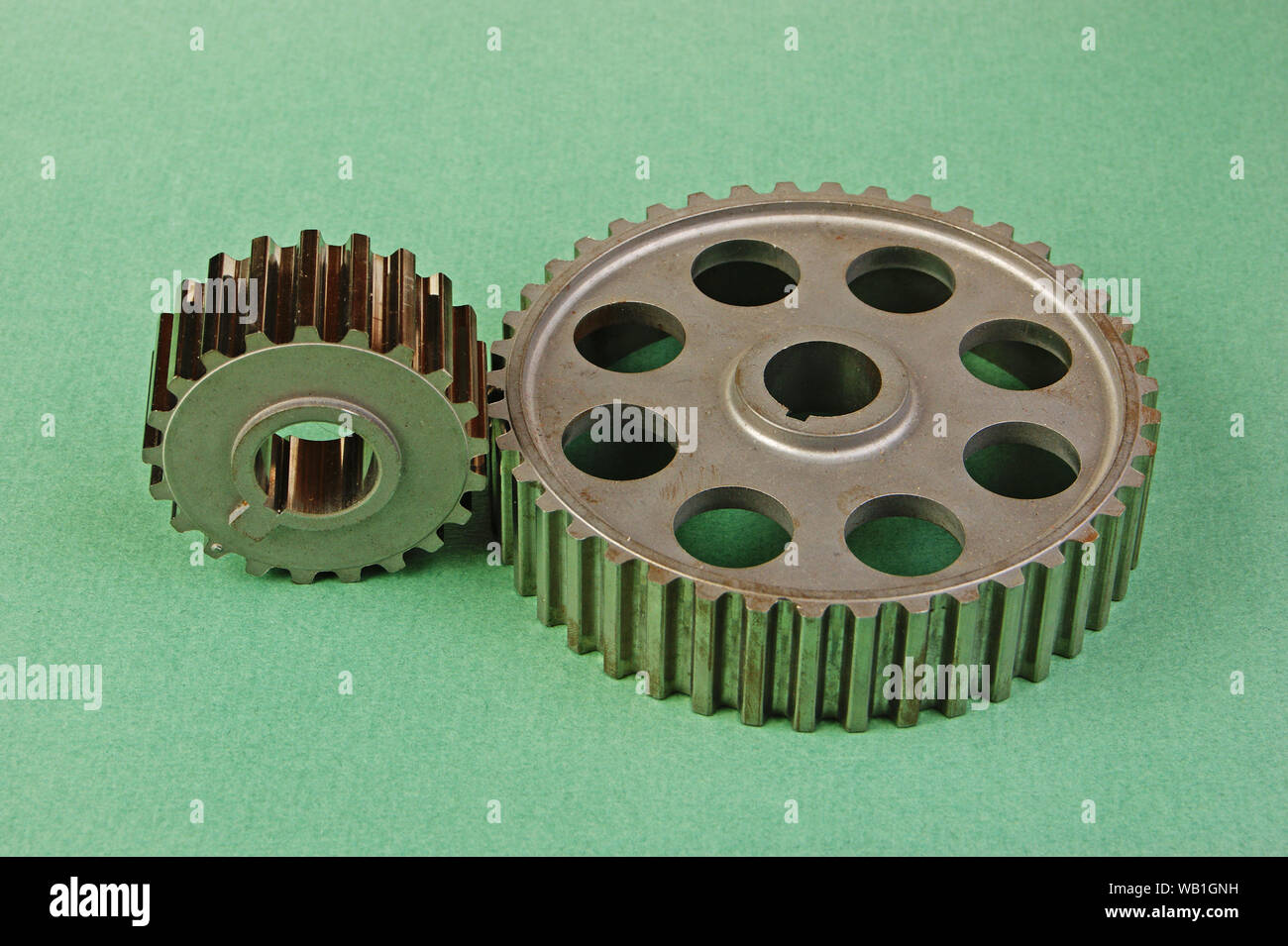 Two gears on a green background Stock Photo - Alamy