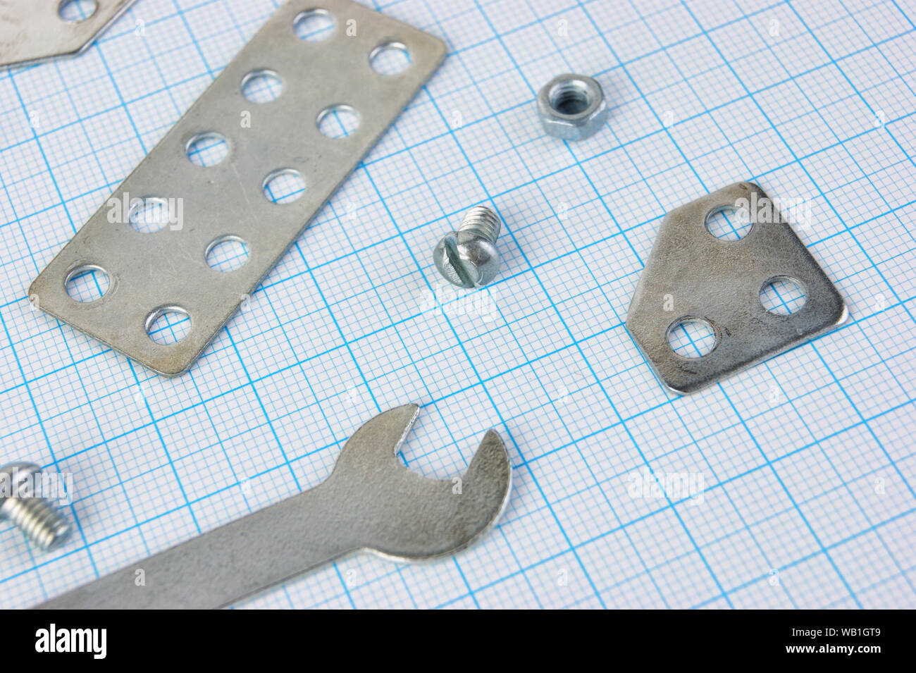 metal parts for constructi on on graph paper Stock Photo - Alamy
