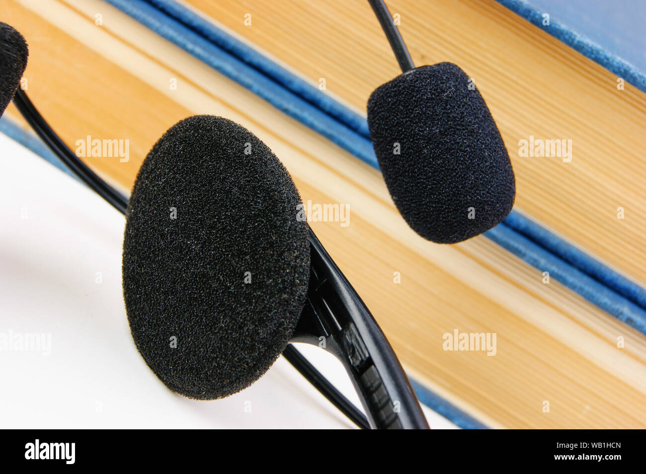 Headphones with a microphone and a stack of books isolated on white ...