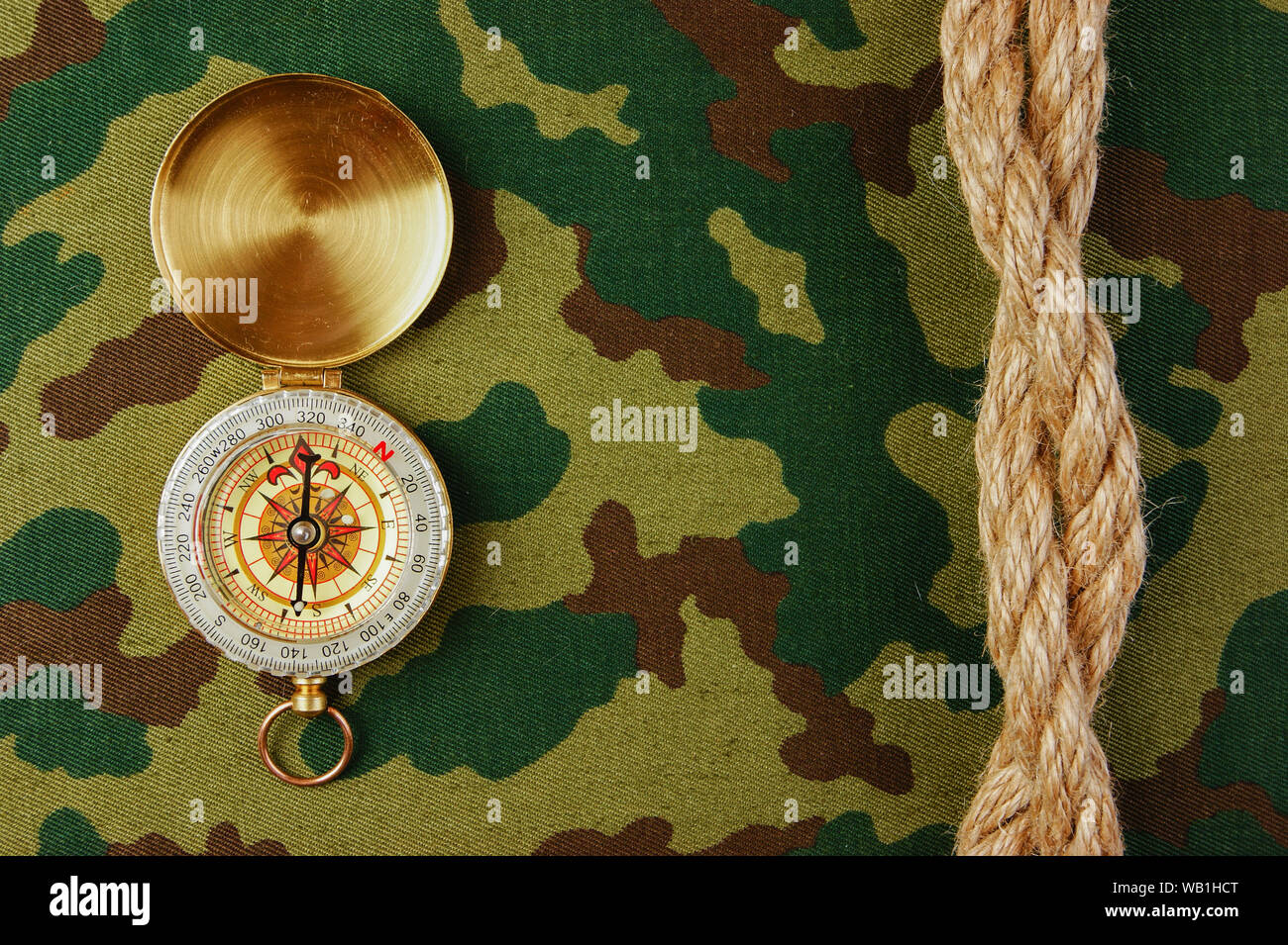 Compass and rope on a camouflage background Stock Photo - Alamy