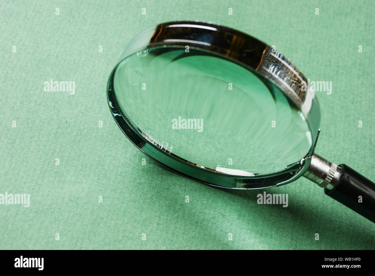 magnifying glass on green background Stock Photo - Alamy