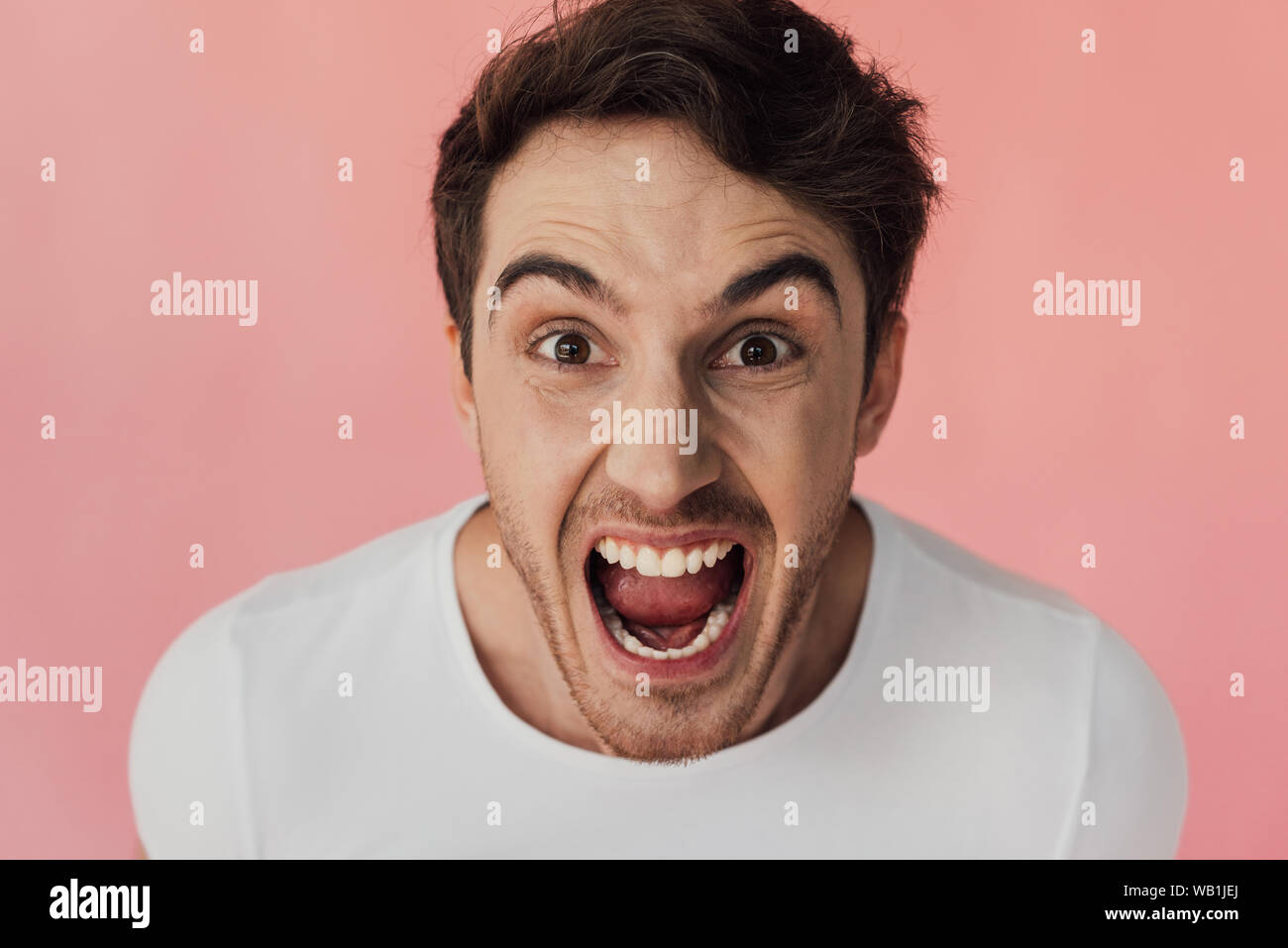 front view of angry man screaming and looking at camera isolated on ...