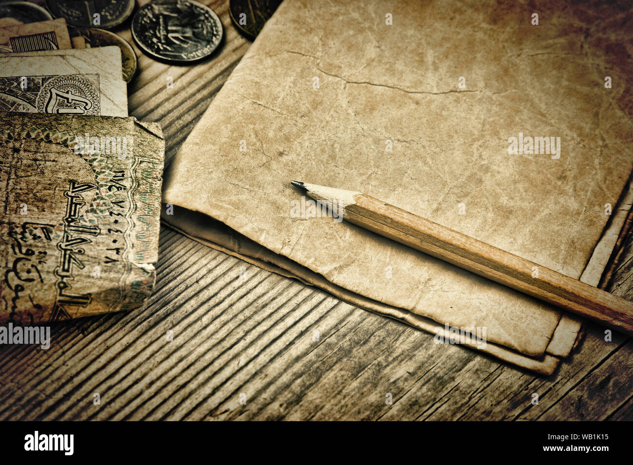 Old notes and coins and pencil on a wooden table Stock Photo - Alamy