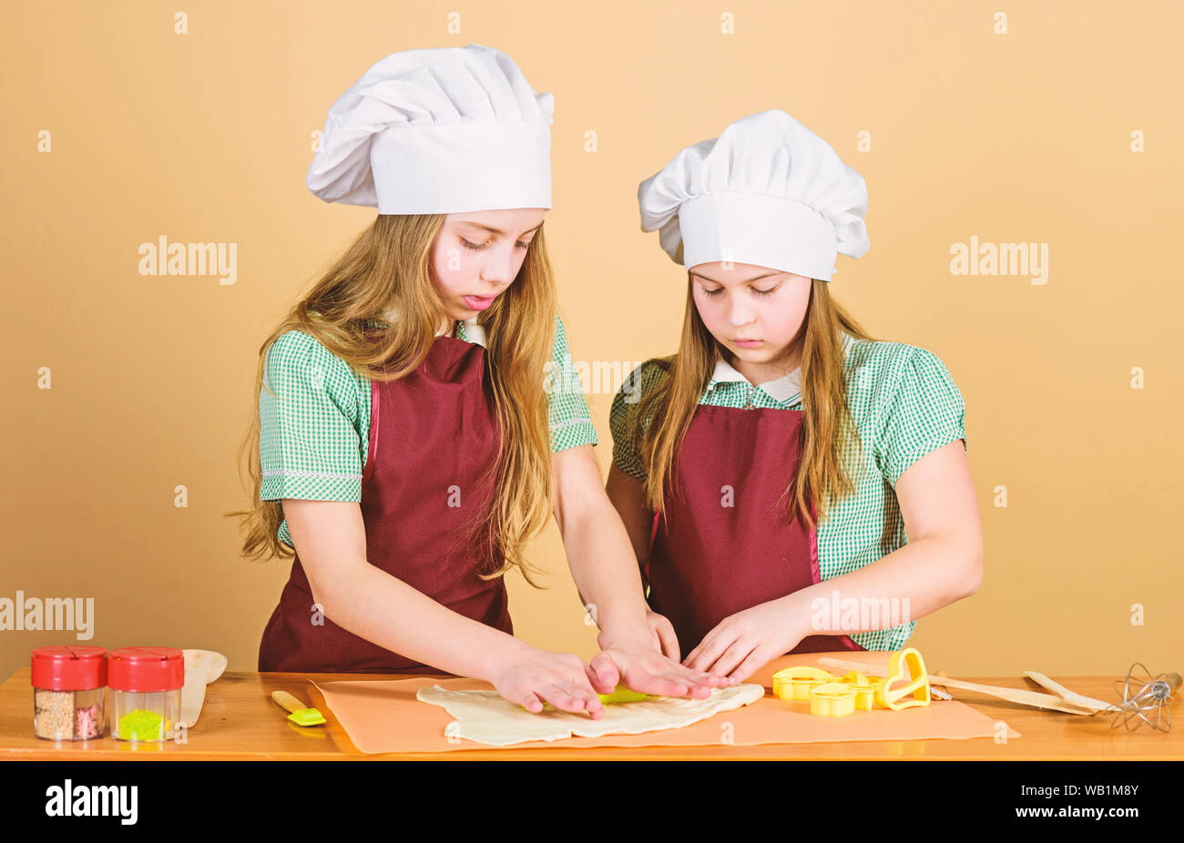 Adorable bakery ladies. Cute little girls kneading dough in bakery shop ...