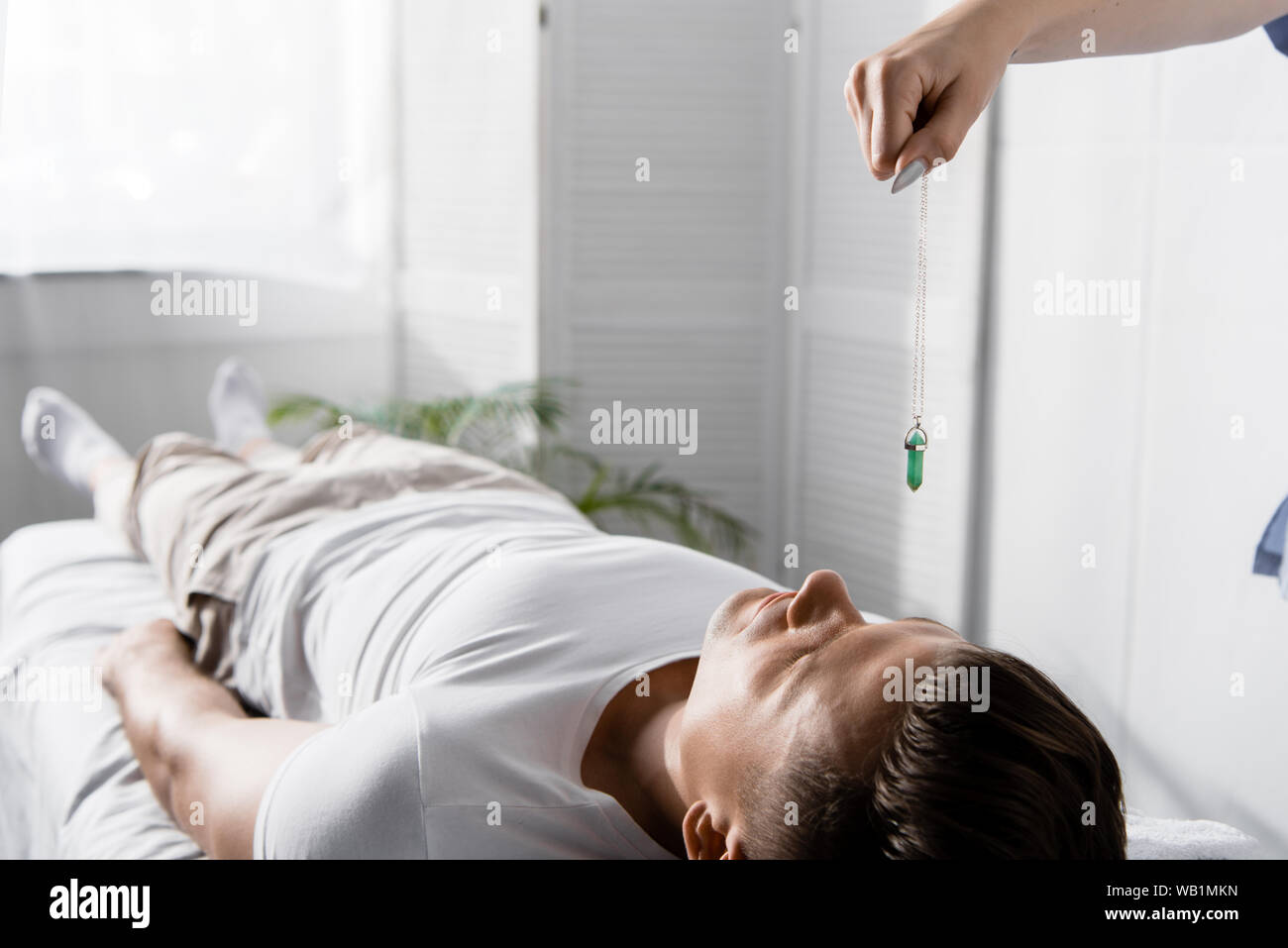 cropped view of hypnotist standing near man on massage table and ...