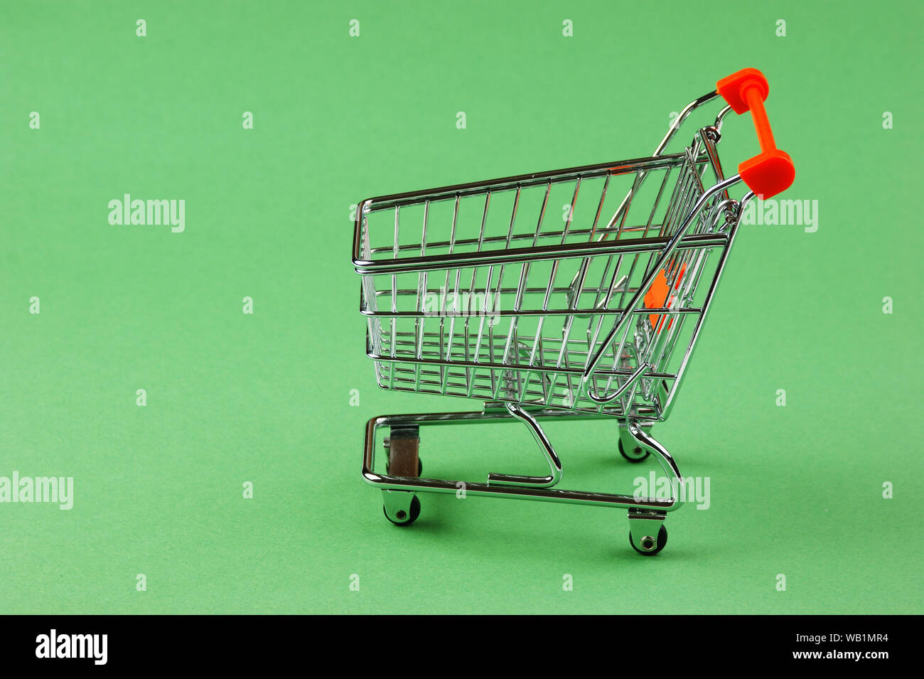 Shopping cart on the green background Stock Photo - Alamy