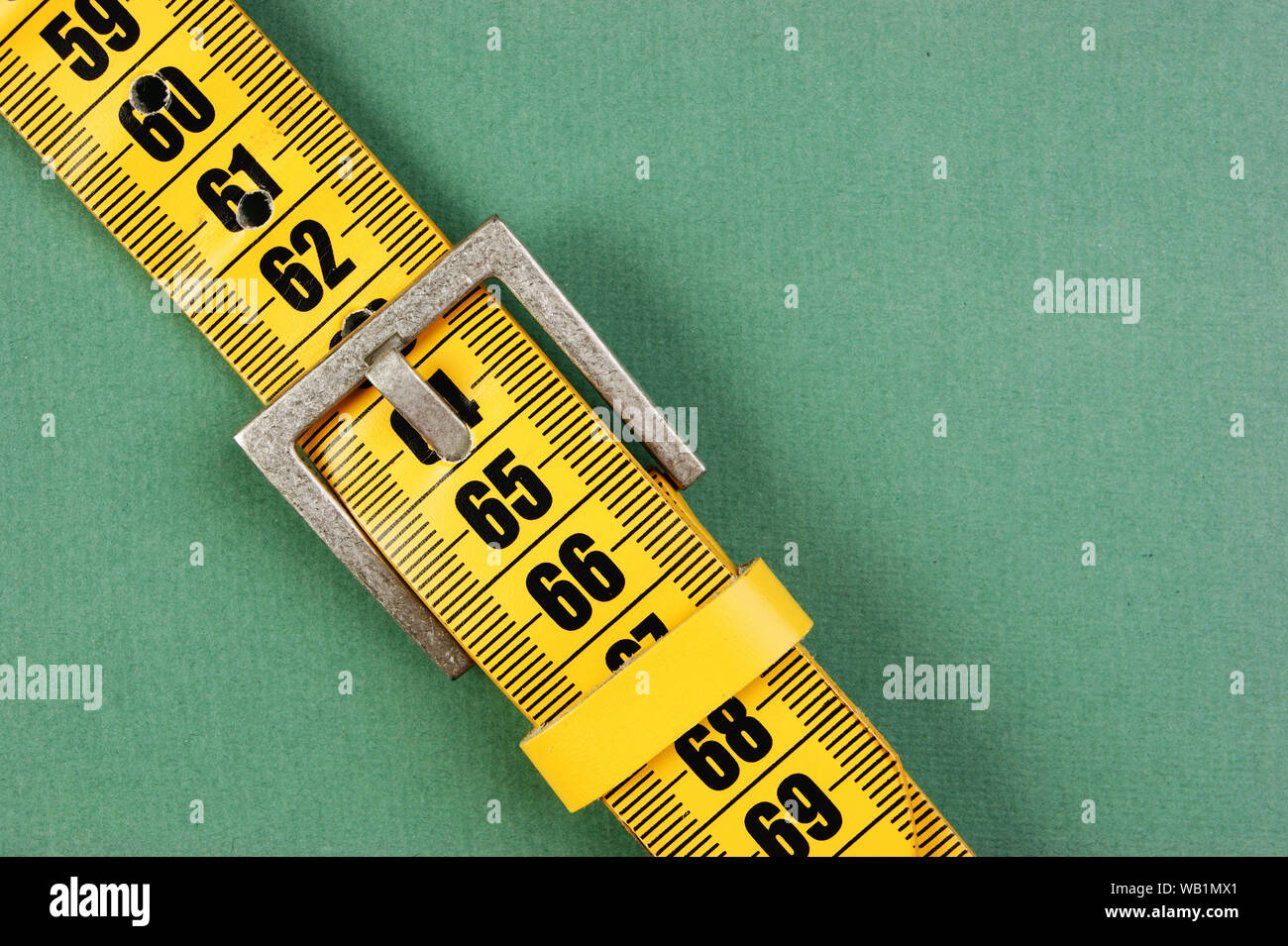 meter belt slimming on the green background Stock Photo - Alamy