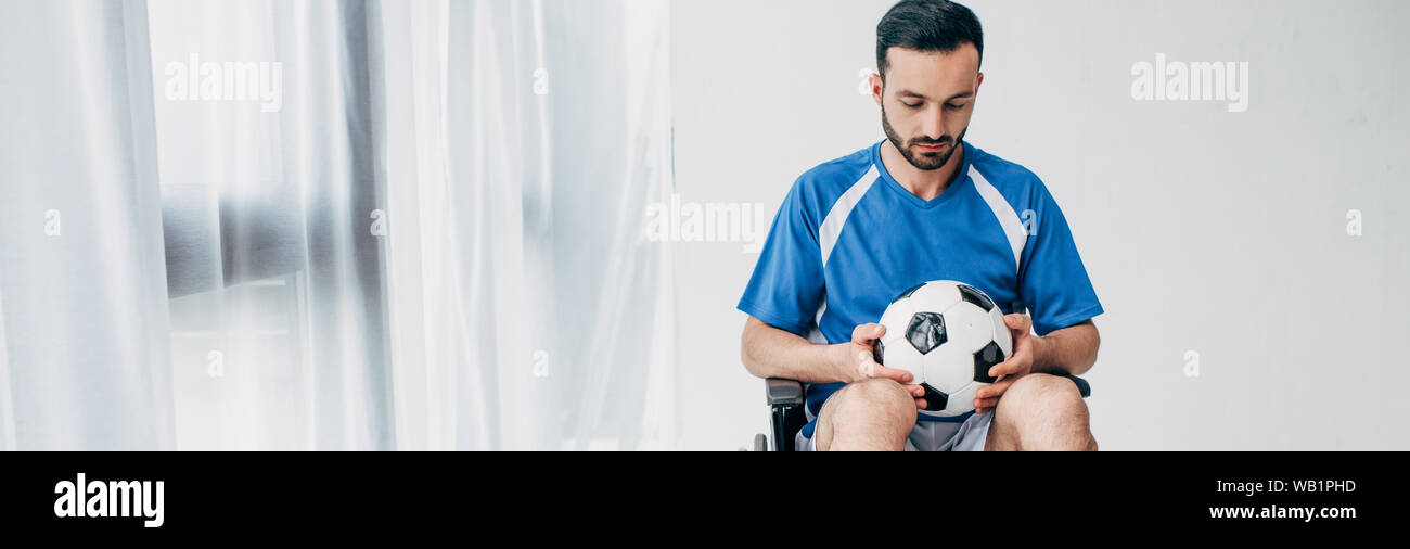 panoramic shot of man in football uniform sitting in Wheelchair and ...