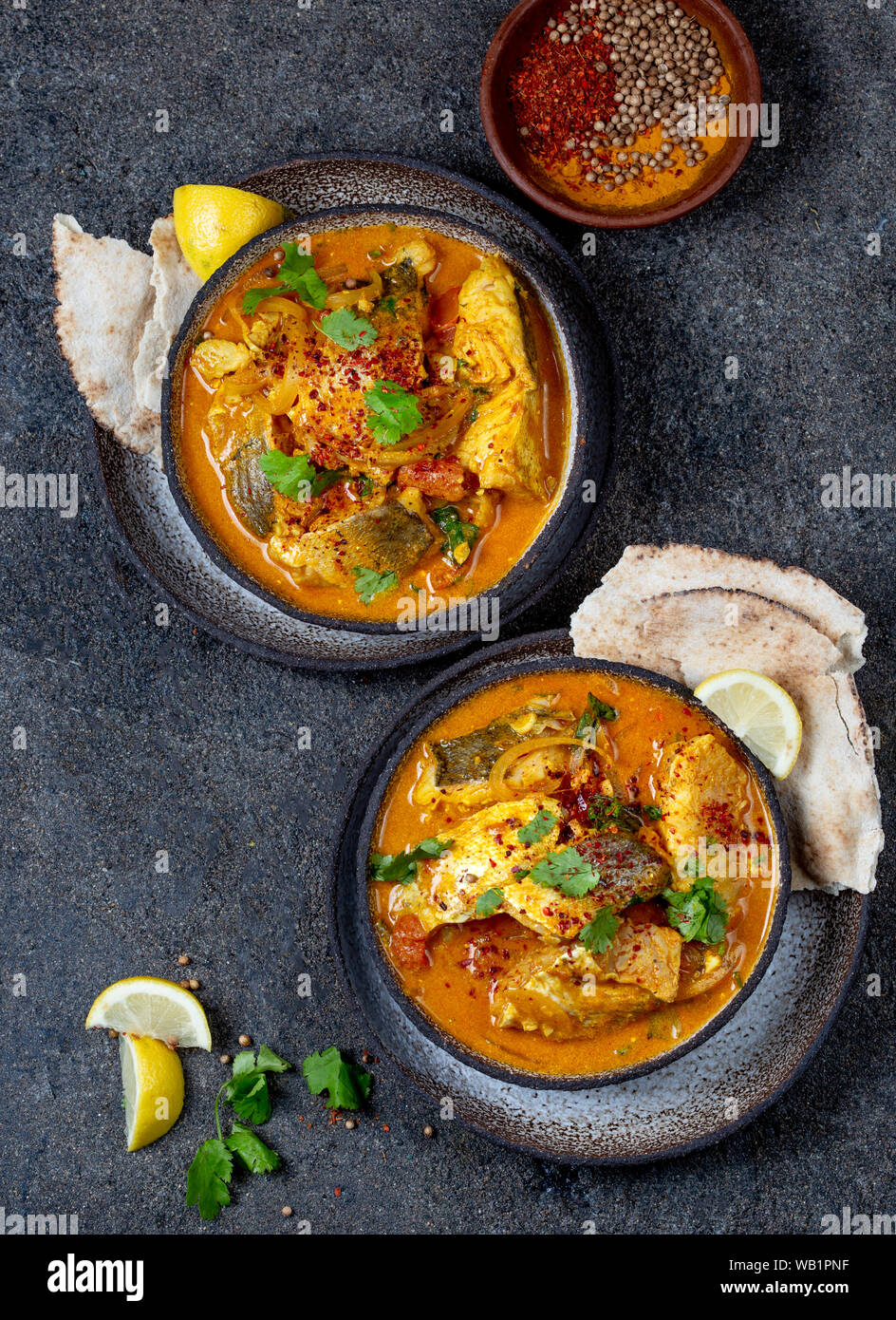 INDIAN FOOD. Traditional KERALA FISH CURRY with naan bread, gray plate ...