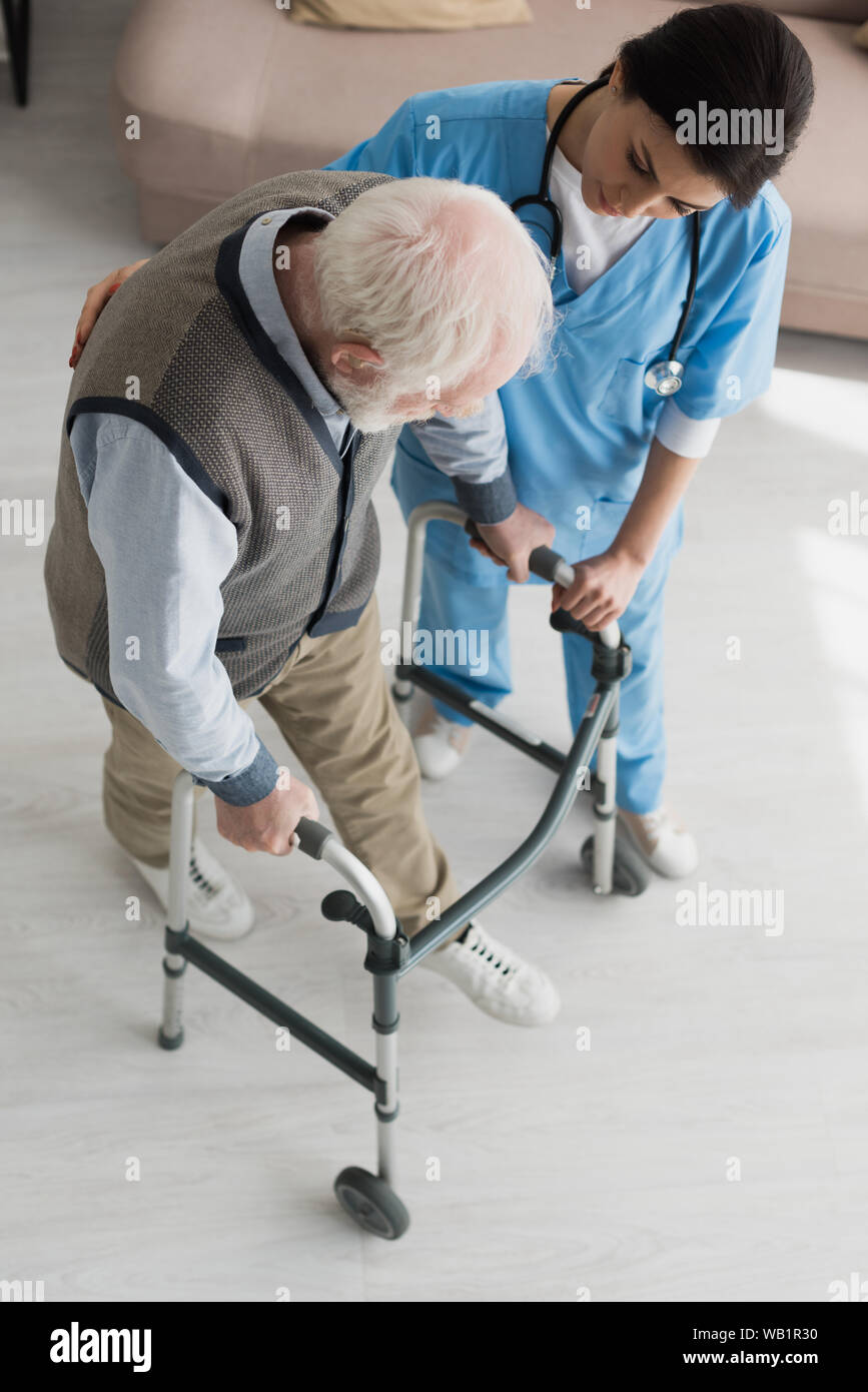 High angle view of doctor helping to senior man walking, recovering ...