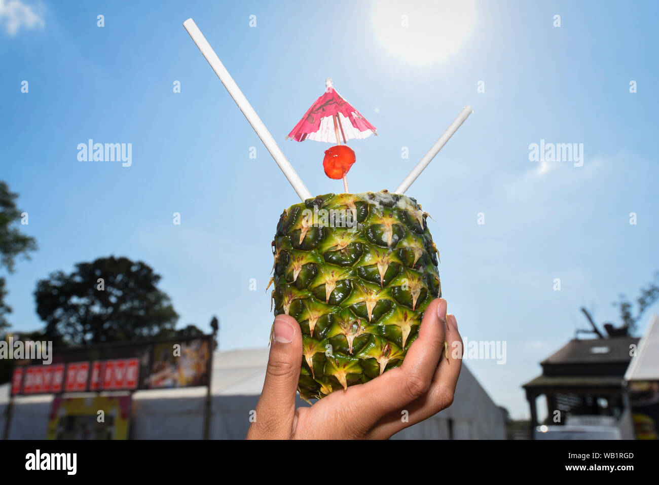 Watford, UK. 23 August 2019. A devotee holds up a a refreshing ...
