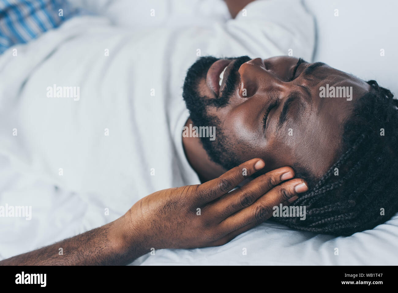 overhead view of african american man suffering from headache in ...