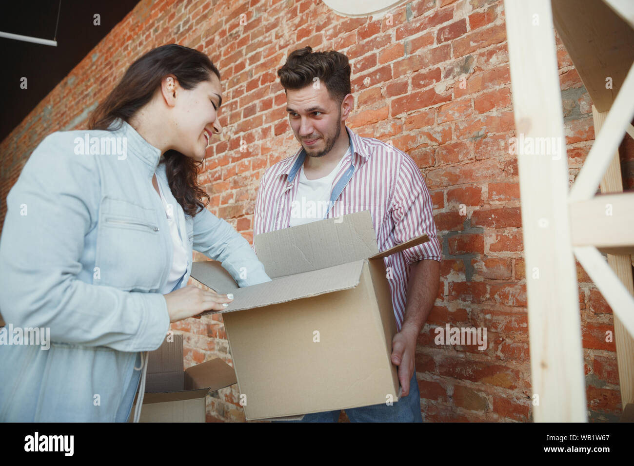 Build the future. Young couple moved to a new house or apartment. Look ...