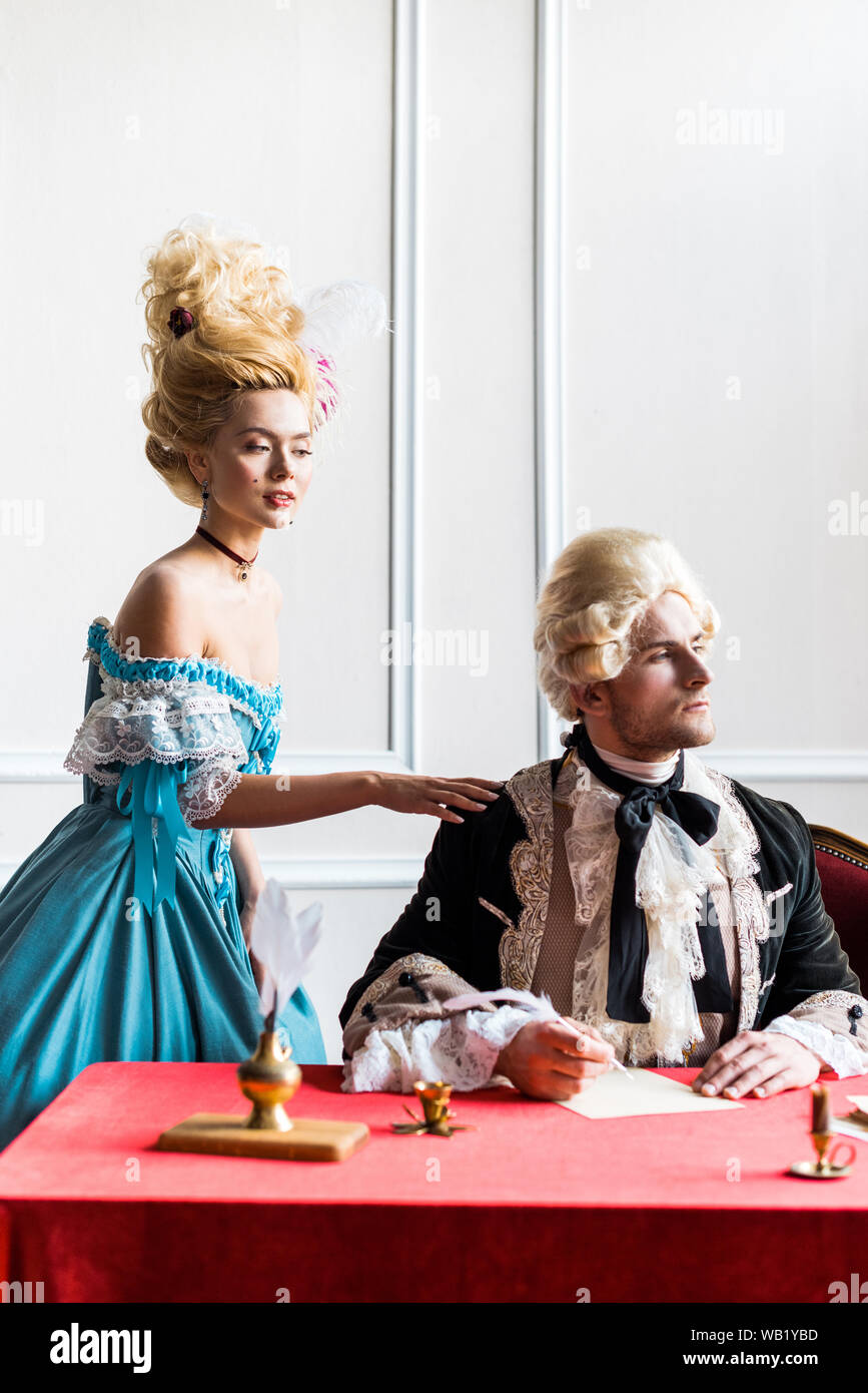 selective focus of victorian woman in wig standing near pompous man ...