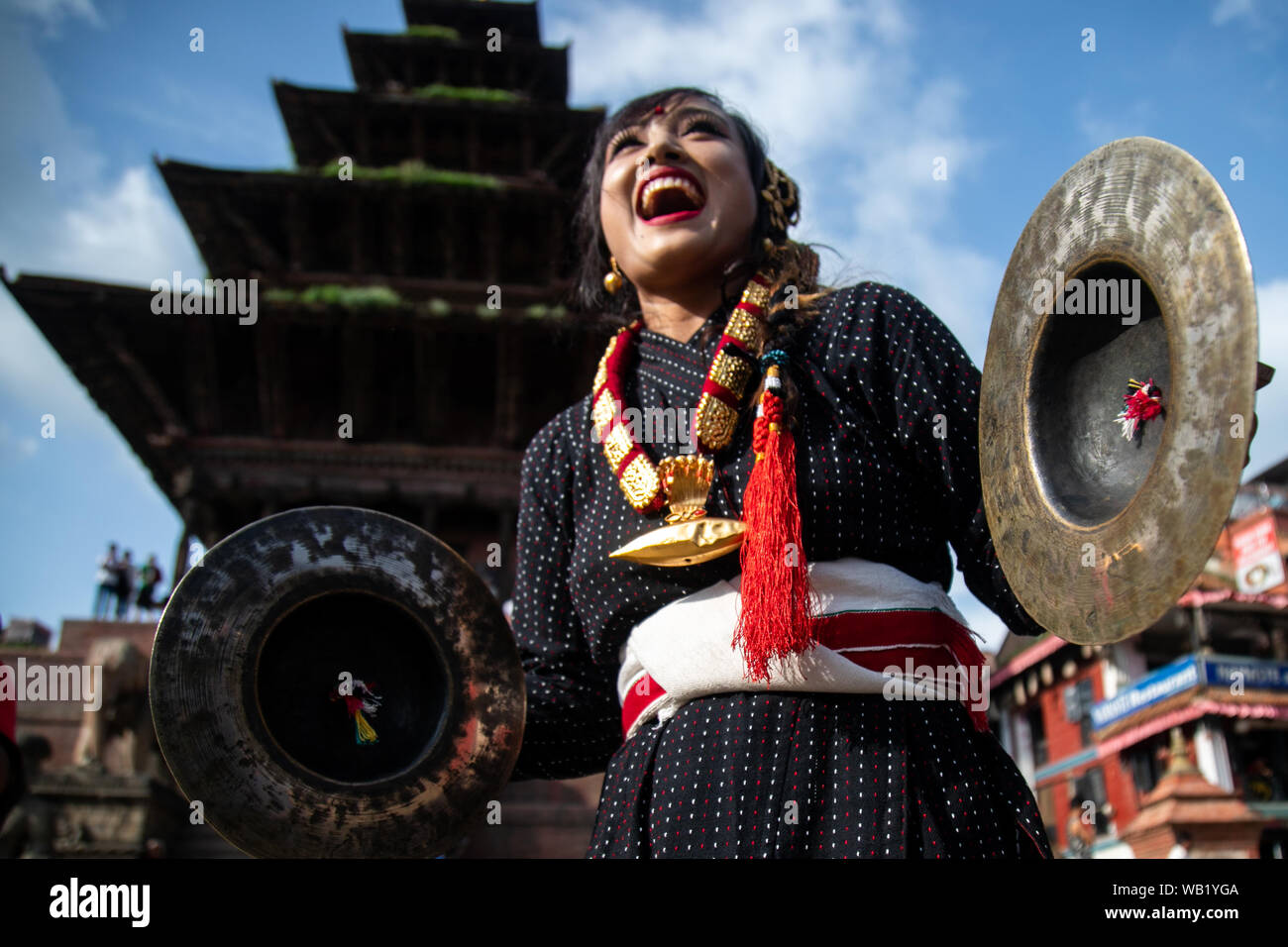 A Nepalese newar Community girl playing traditional instrument while ...