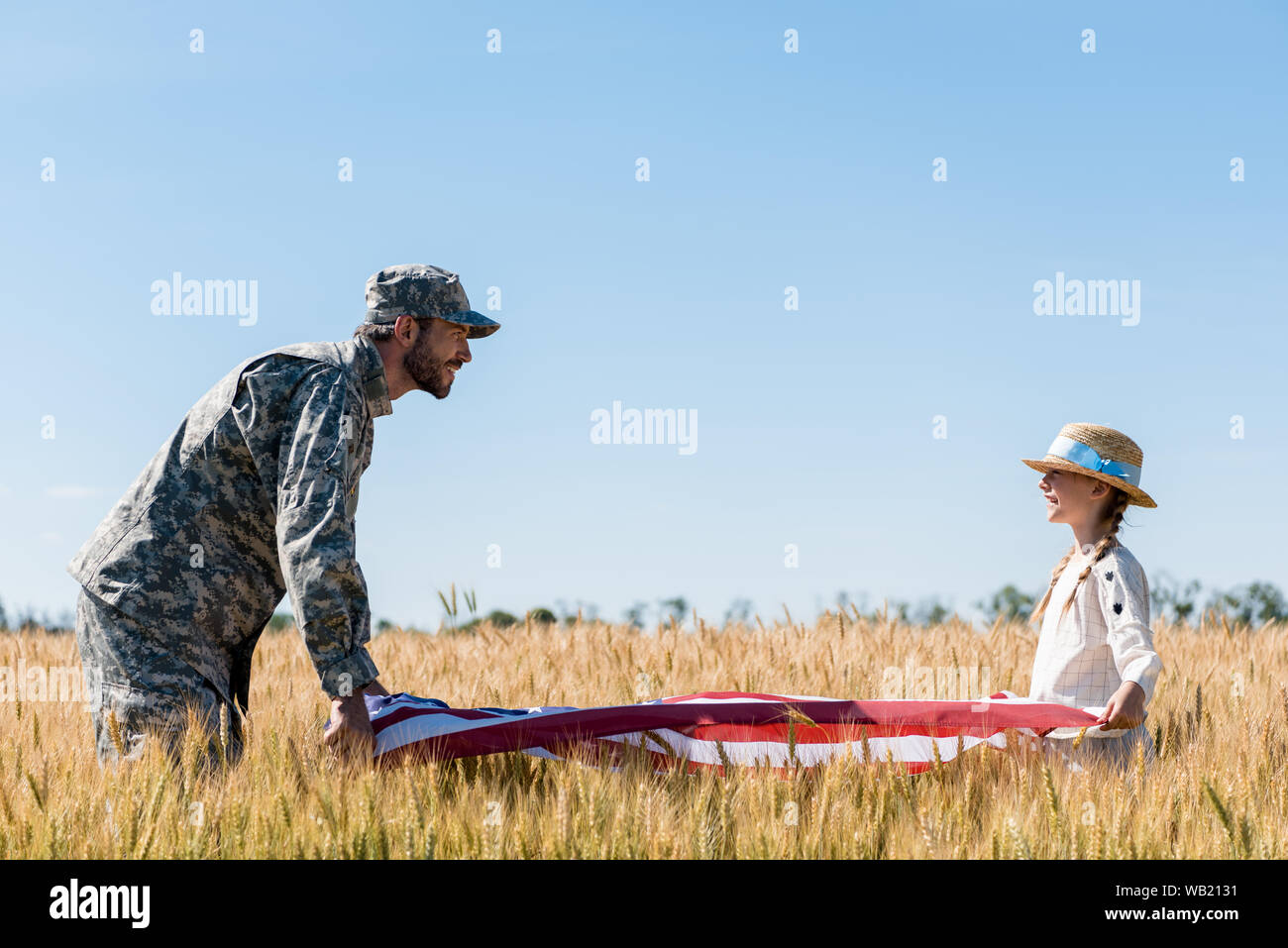 soldier in uniform and happy child holding american flag in field Stock ...