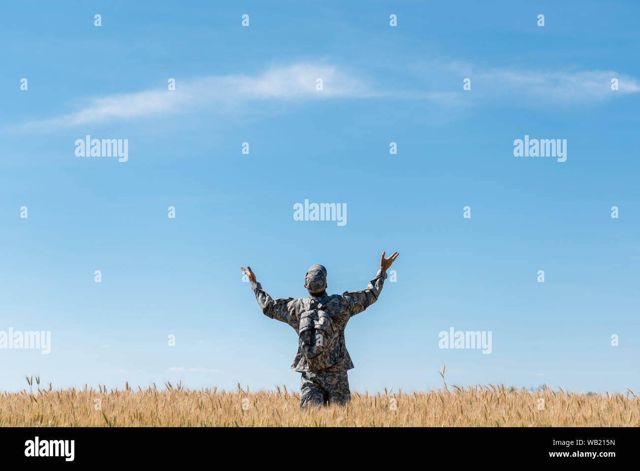 back view of soldier in military uniform standing with outstretched ...
