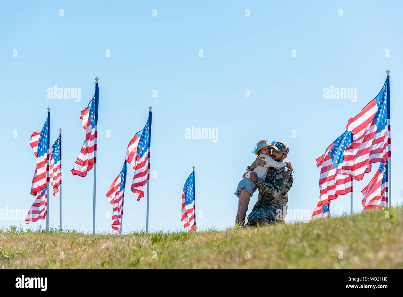 cute kid hugging father in military uniform near american flags Stock ...