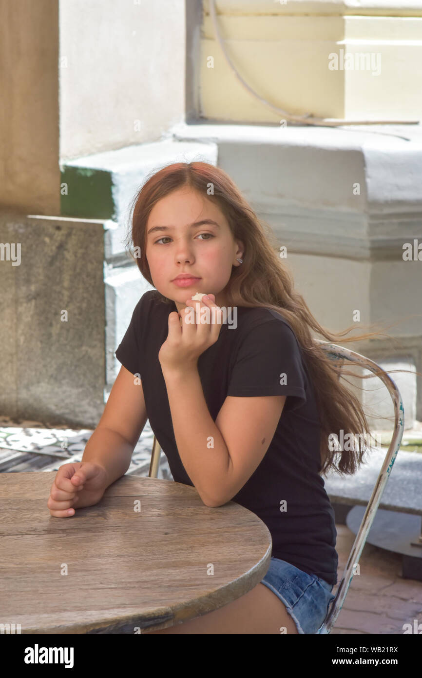 Young beautiful woman eating bar. Beautiful little girl eating coconut ...