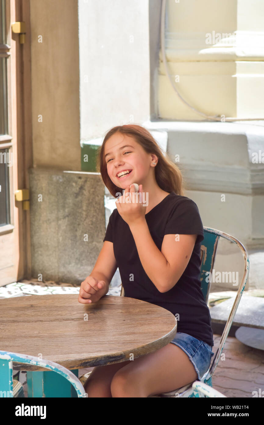 Young beautiful woman eating bar. Beautiful little girl eating coconut ...