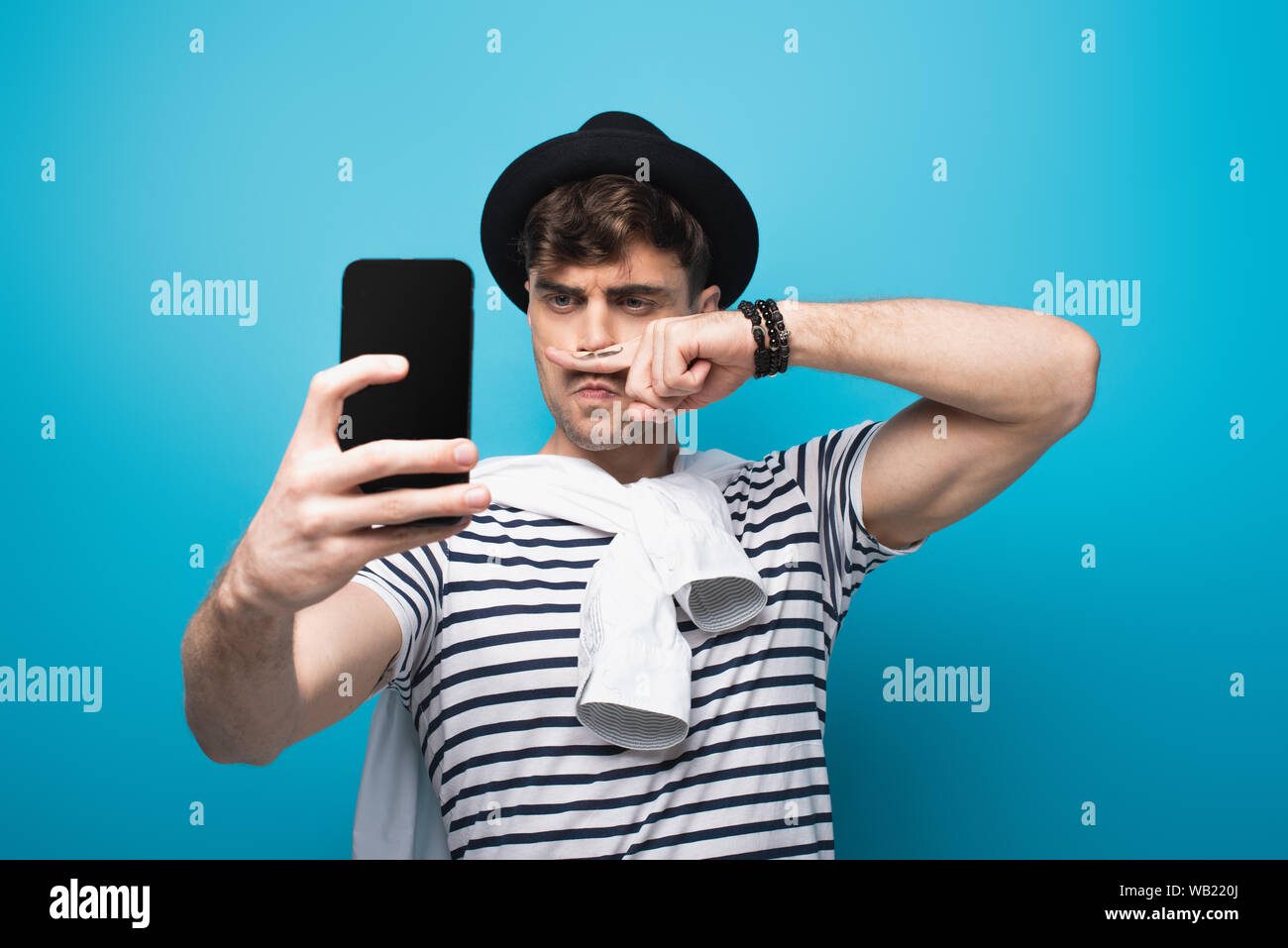 Tricky Man Taking Selfie With Smartphone While Holding Finger With