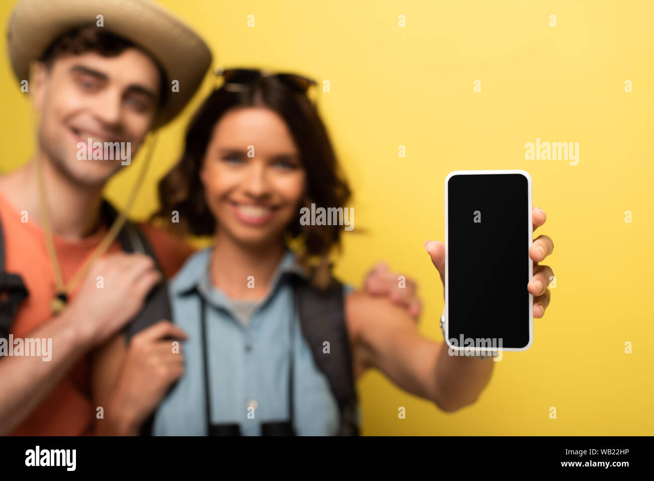 selective focus of cheerful young woman standing near smiling boyfriend ...