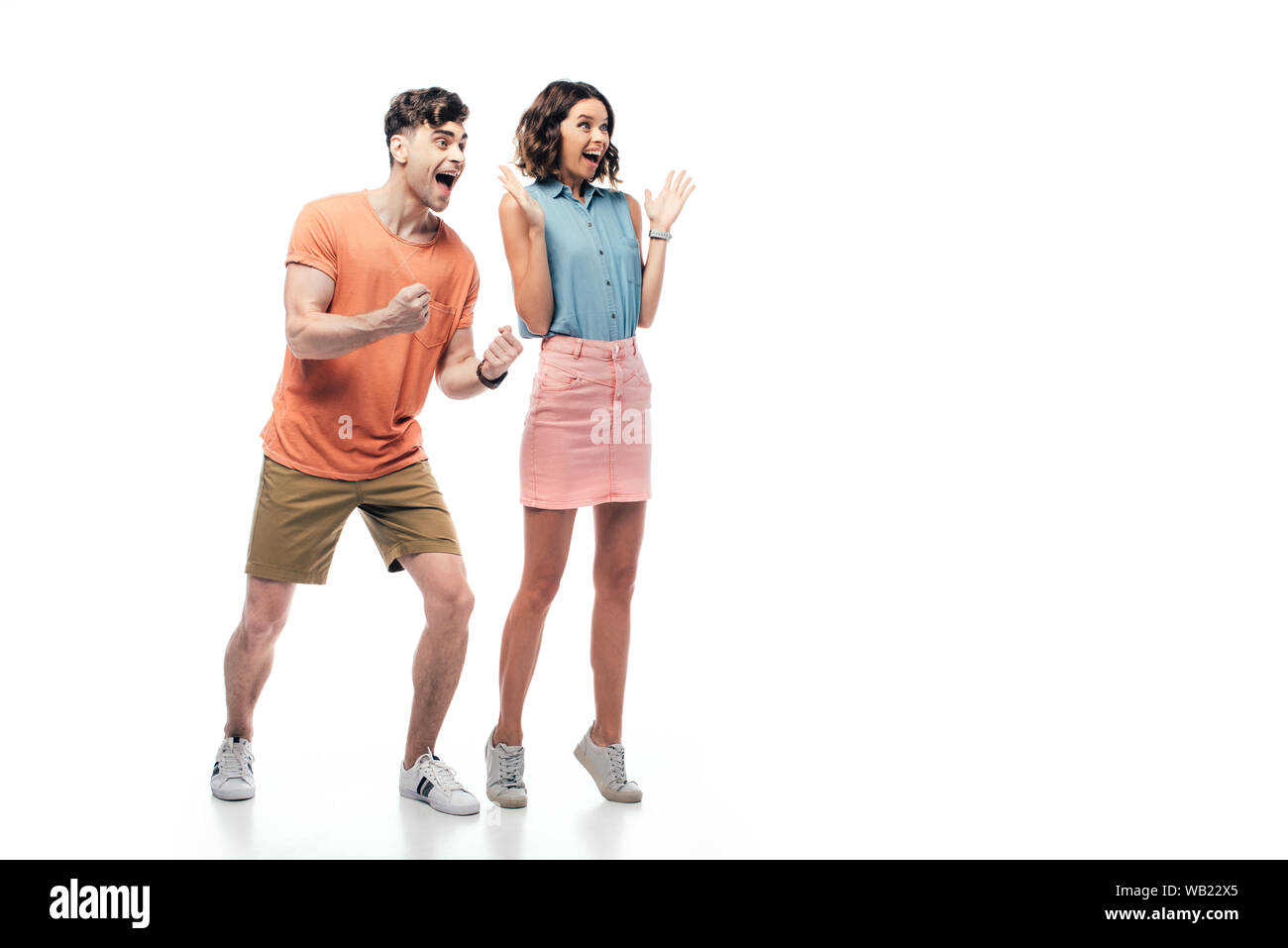 excited man and woman showing yes gestures and looking away on white ...