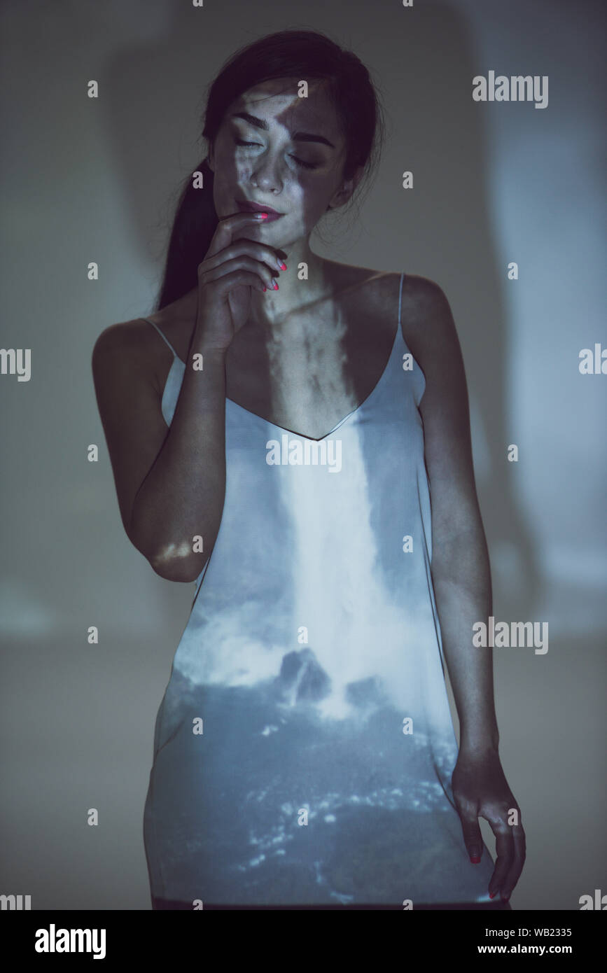 beautiful woman standing in darkness with closed eyes in pose Stock ...