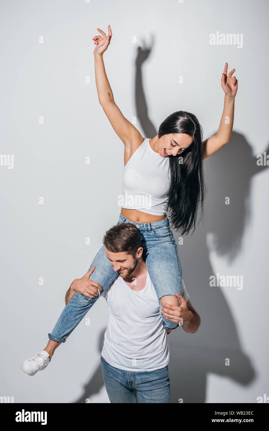 beautiful girl sitting on shoulders of boy with hands in air Stock ...