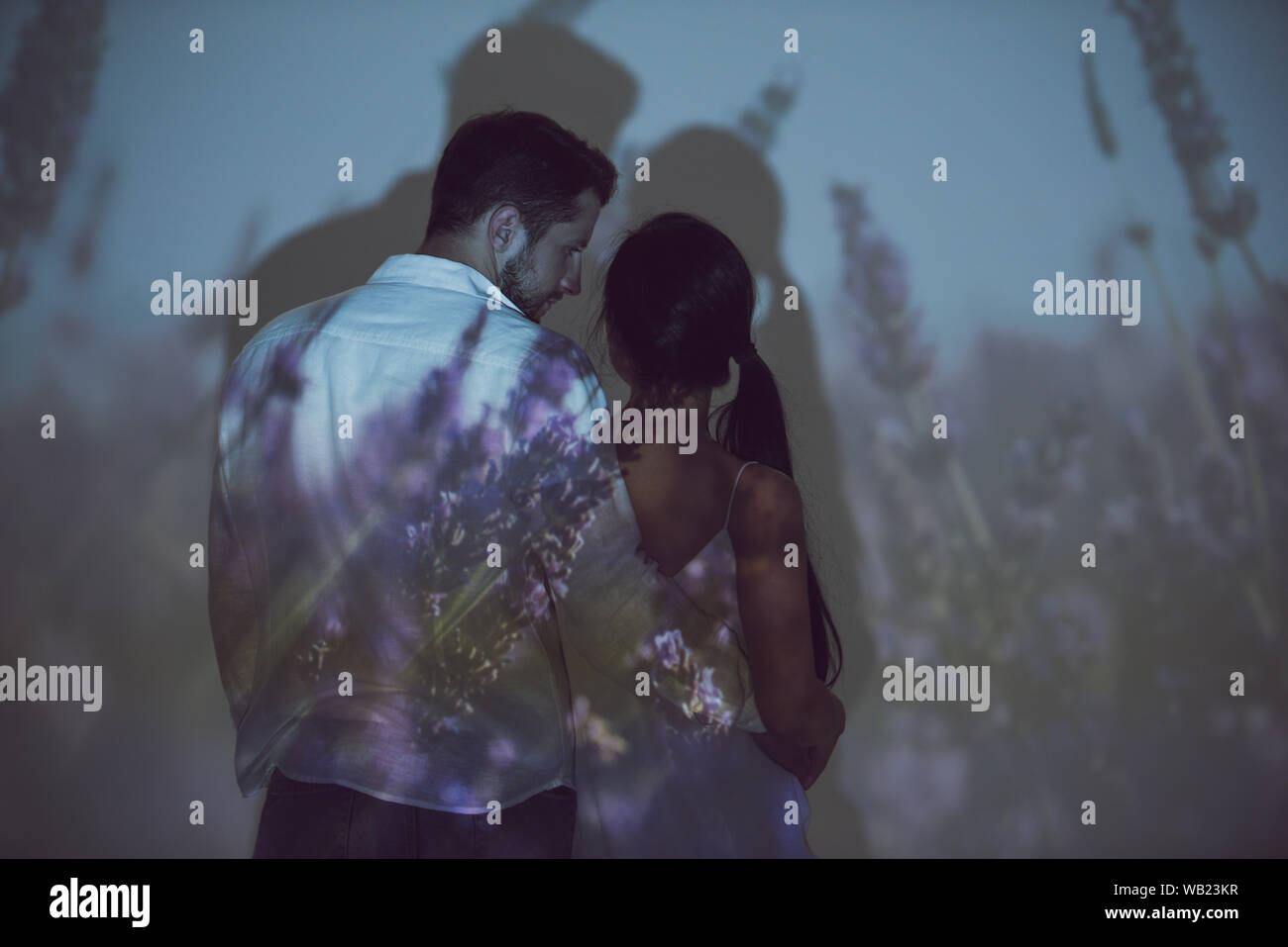 back view of girl and man hugging and looking at each other while ...