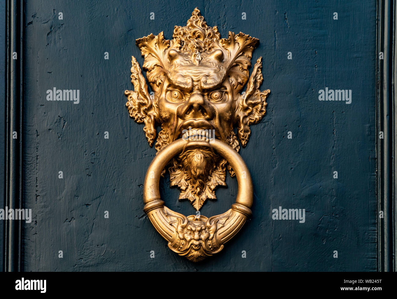 Chinese demon golden door handle - knocker in a green wooden door Stock ...