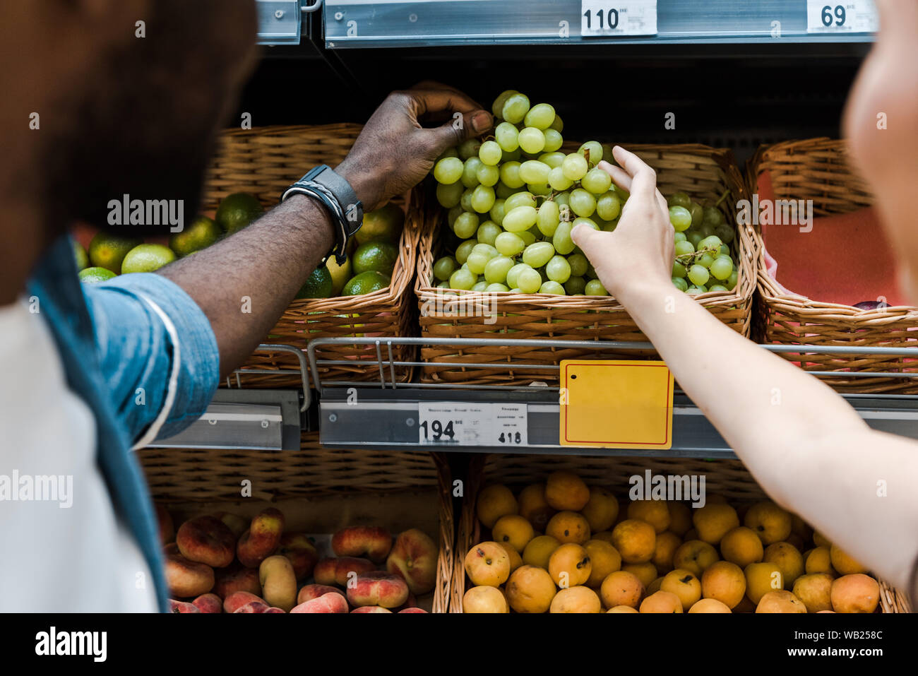 selective focus of african american man and woman taking grapes in ...