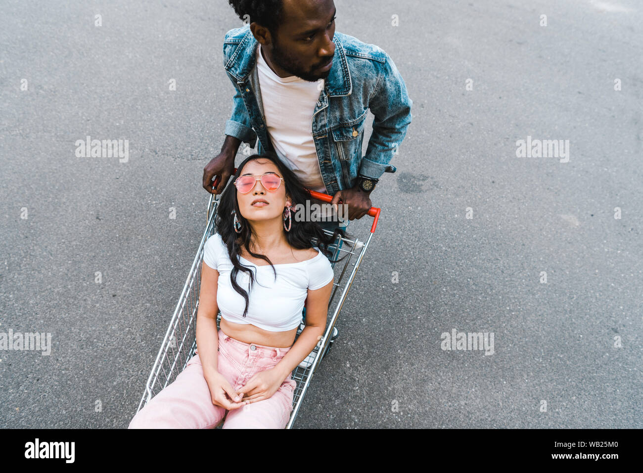 overhead view of african american man standing near asian girl sitting ...